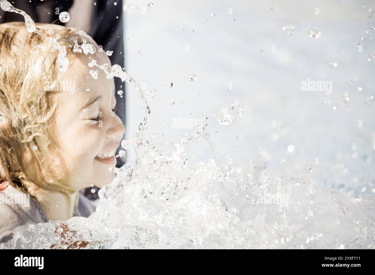 A young girl splashes water as she learns to swim Stock Photo - Alamy