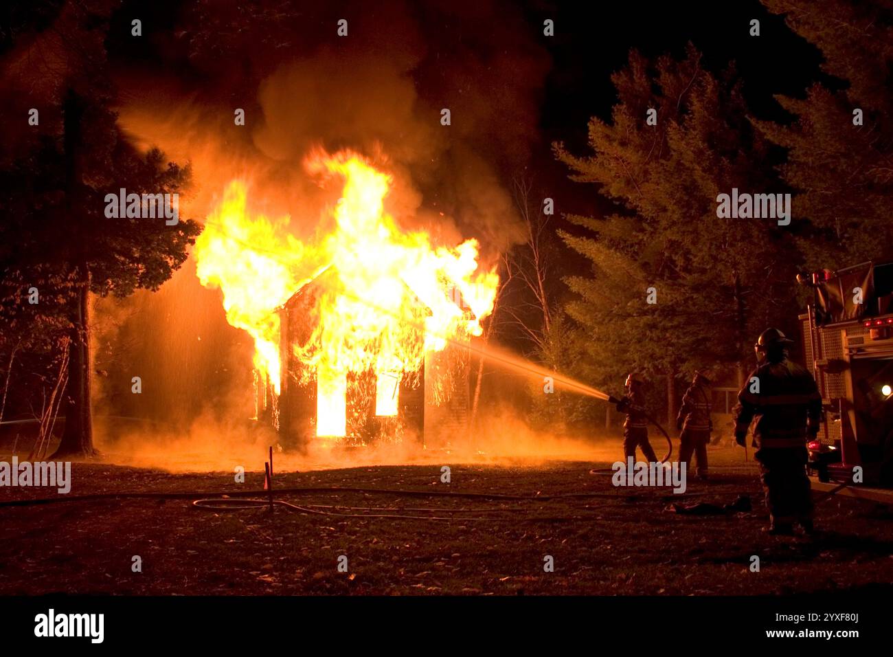 Firefighters control the fire of a burning house Stock Photo - Alamy