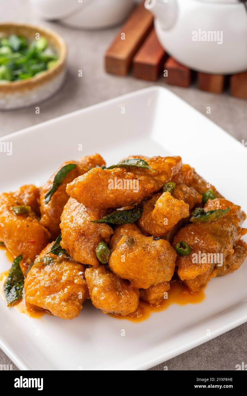Crispy fried dori fish coated with salted egg plated on a white plate ...