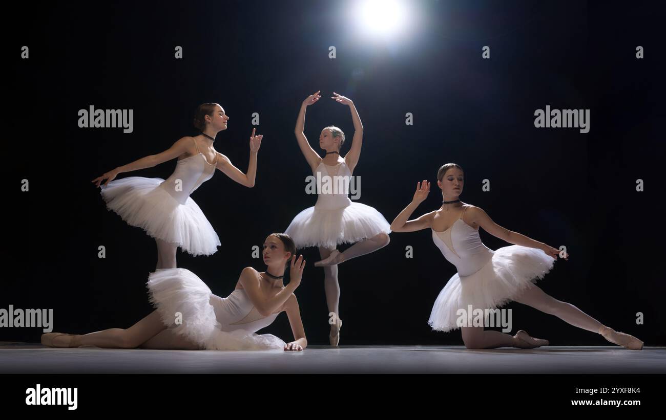 Four young girls, ballet dancers performing dramatic and elegant dance ...