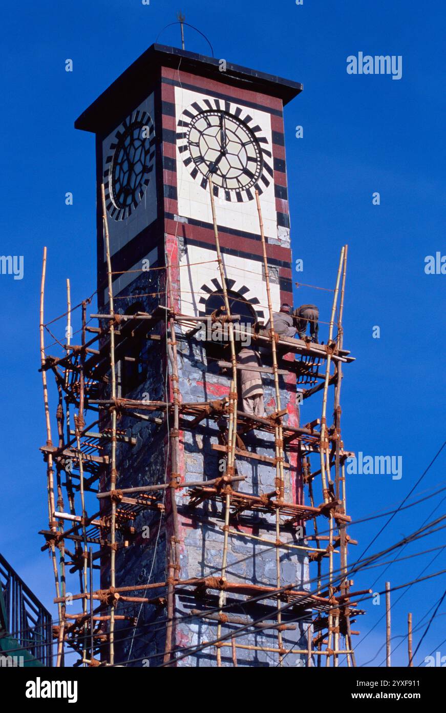 Men working to repair a clock tower in the town of Mussoorie, India ...