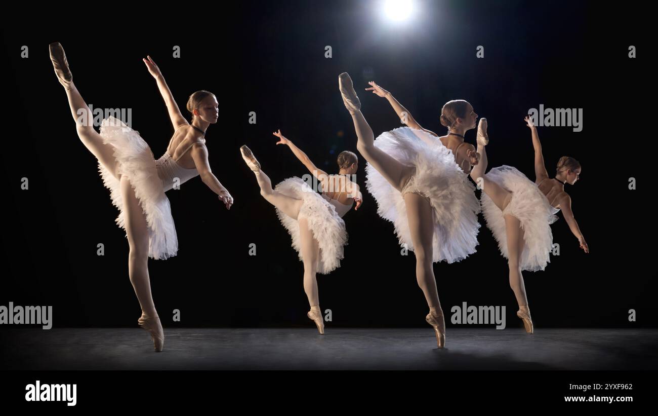 Ballerinas performing under dramatic spotlight, creating striking visual of elegance and ...