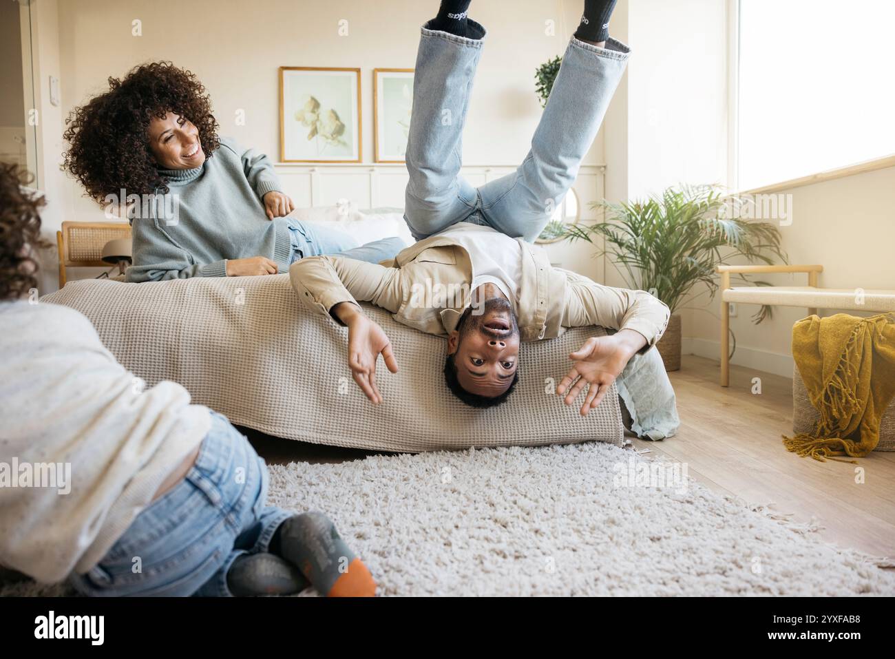 A cheerful family shares a funny moment in their cozy bedroom ...
