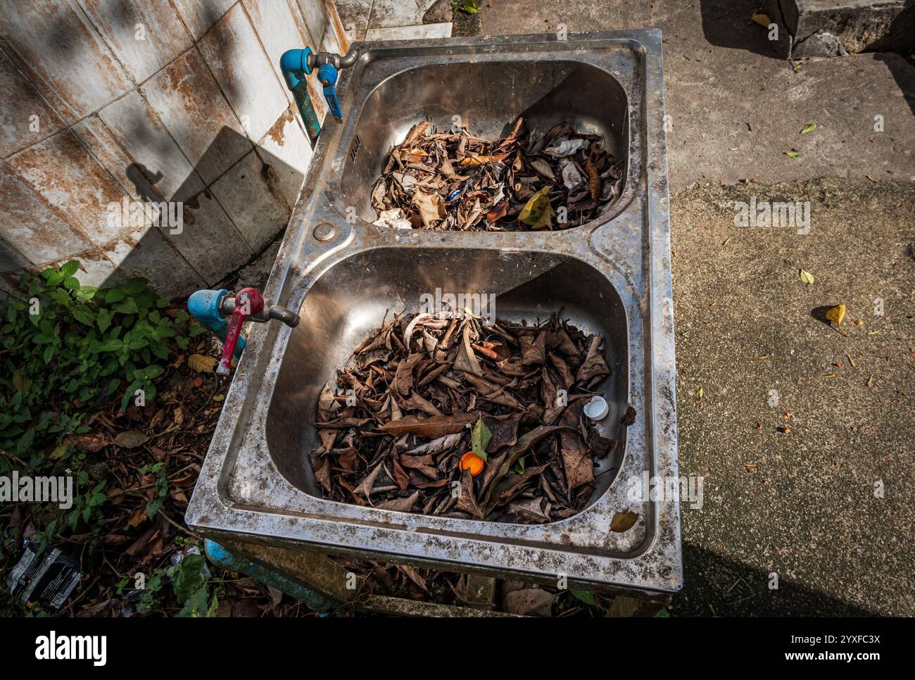 Old abandoned unused metal sinks and taps at outside of a Buddhist ...
