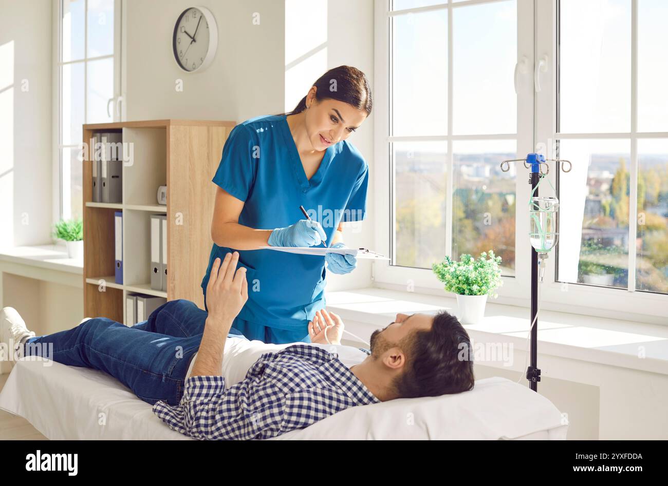 Male patient lying on couch in medical clinic and receiving IV drip ...