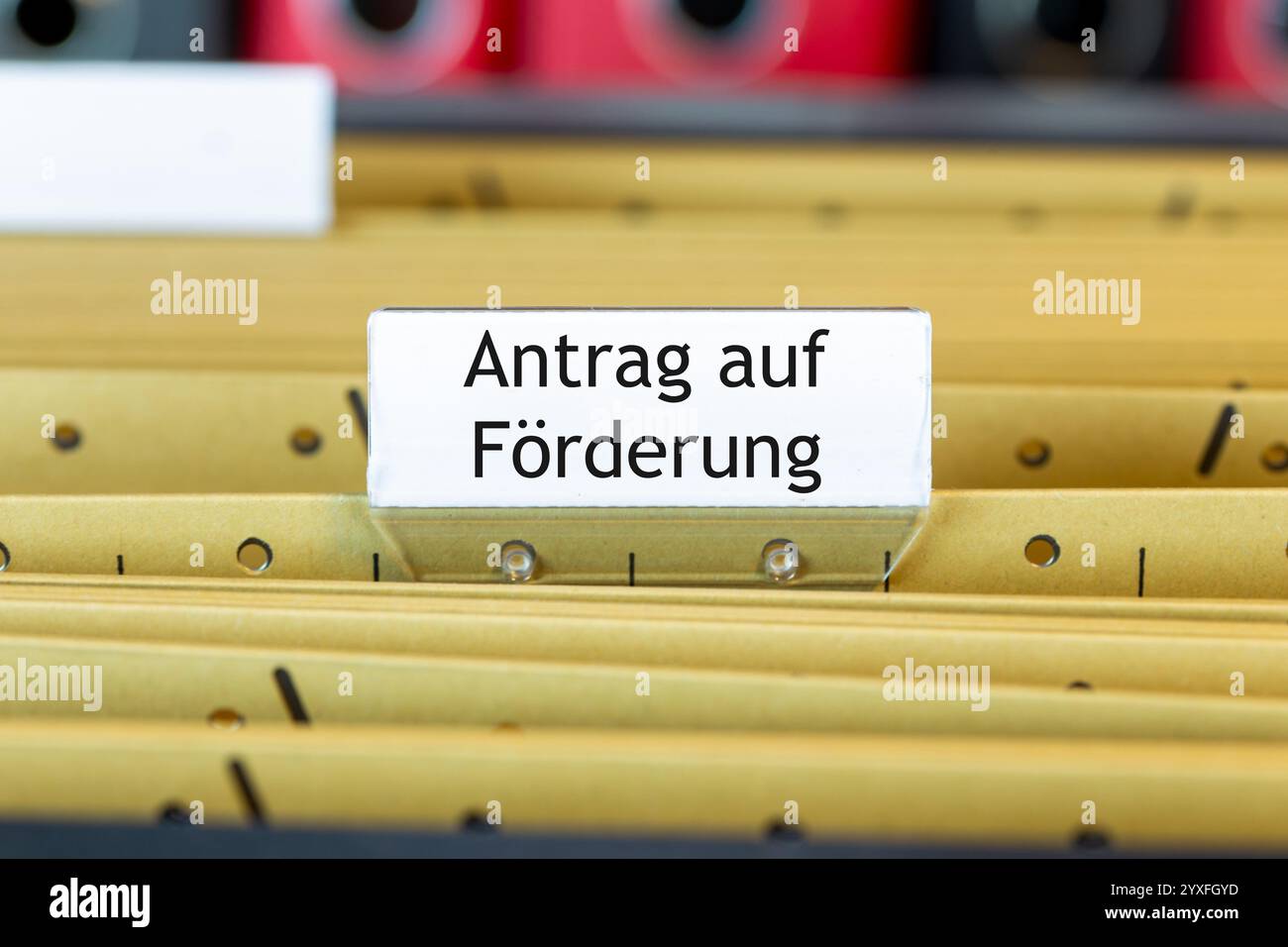 Sign with the inscription ANTRAG AUF FÖRDERUNG on a suspension file ...