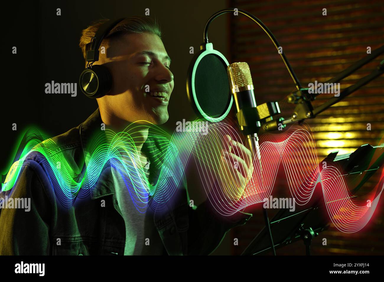Vocalist with headphones singing into microphone in professional record ...