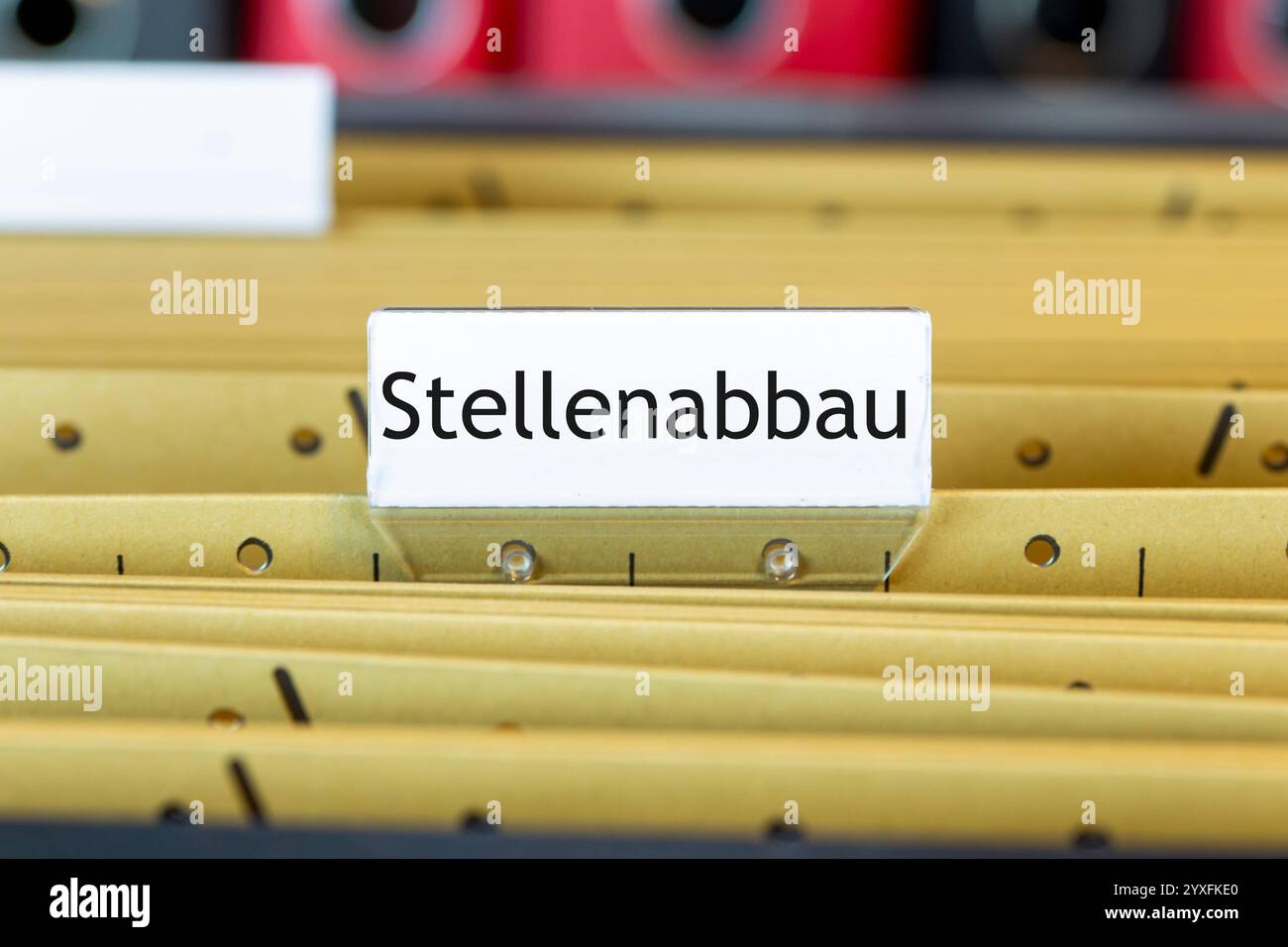 Schild mit der Aufschrift STELLENABBAU an einem Hängemappenregister ...