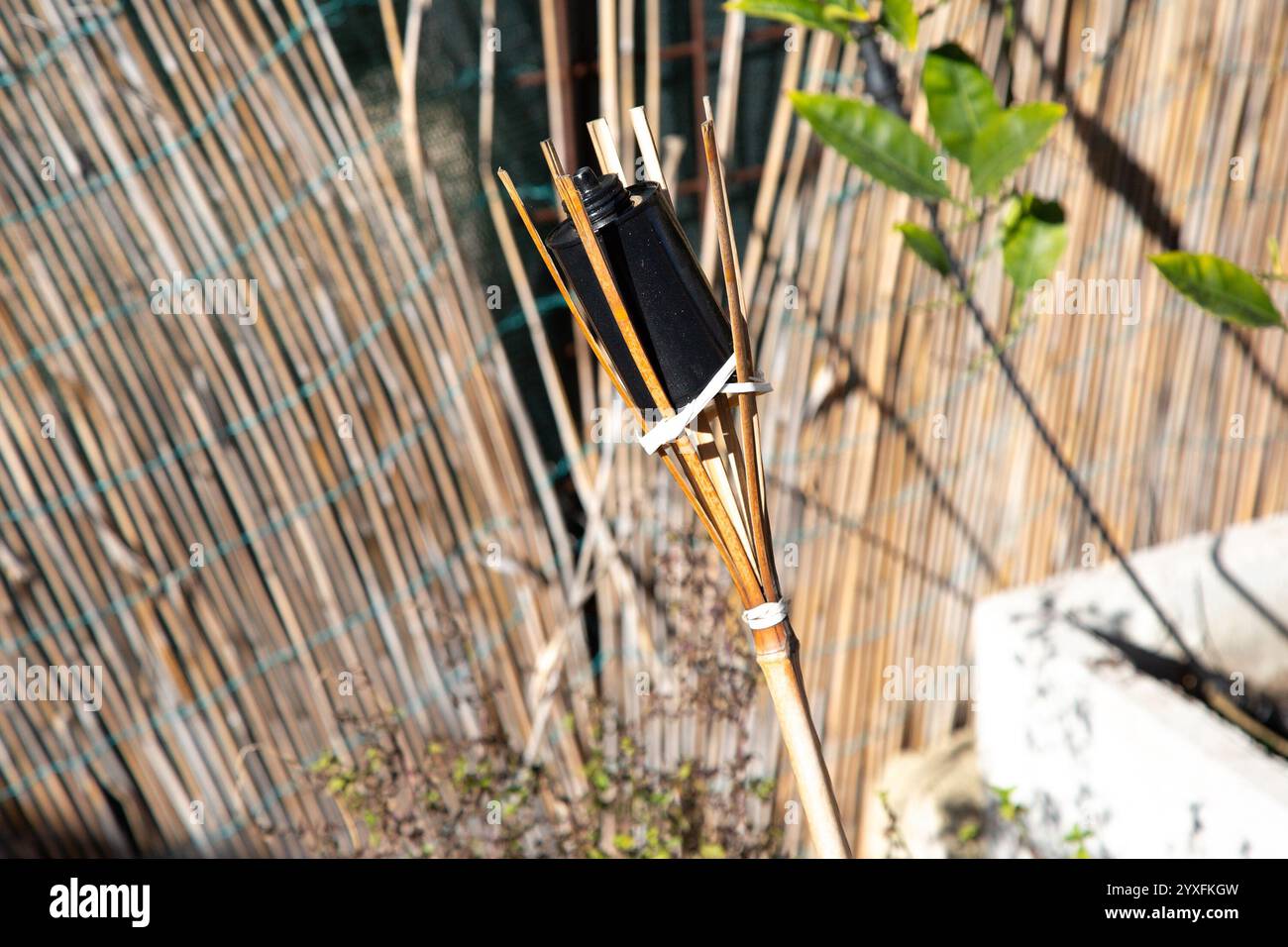 A beautifully crafted bamboo torch is positioned in front of a bamboo ...