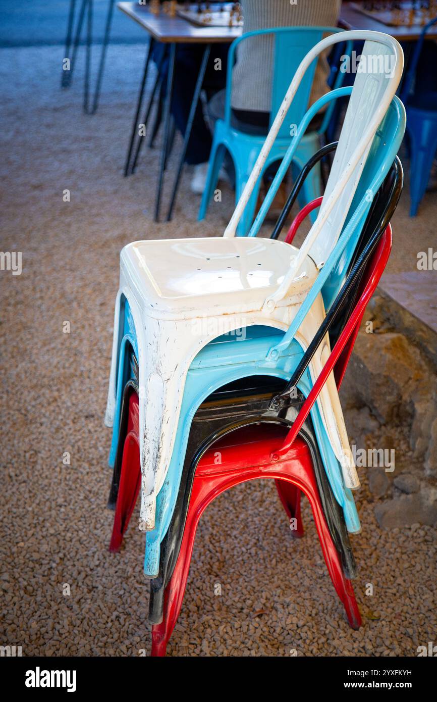 A stack of colorful chairs piled up on the ground Stock Photo - Alamy