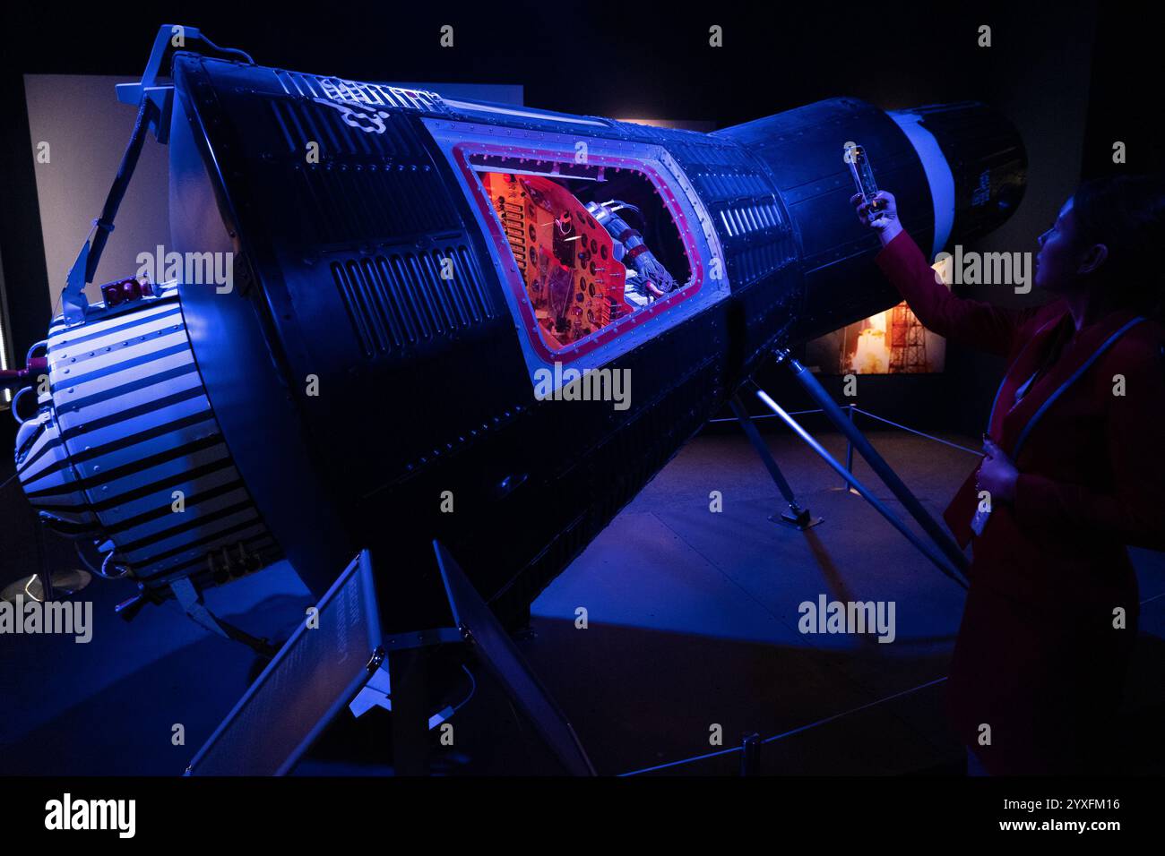 A visitor takes a photo of a Mercury Friendship 7 model on display ...