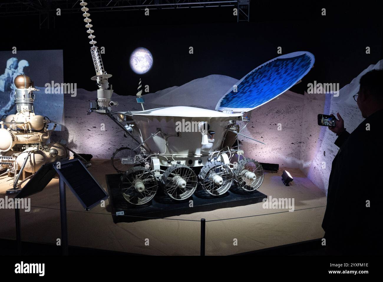 A visitor takes a photo of a lunar rover "Lunokhod" model on display ...