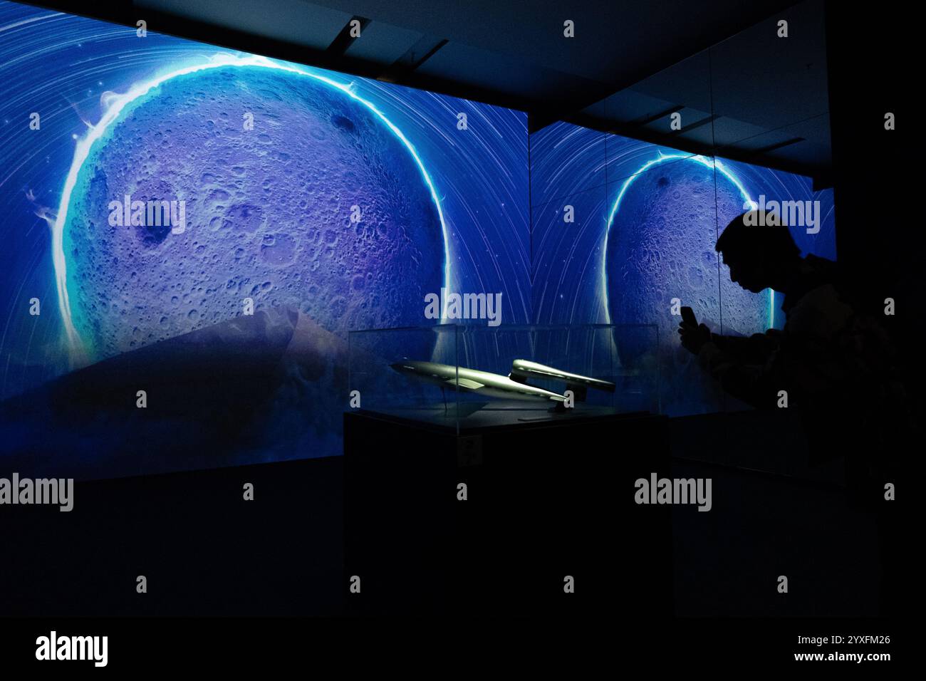 A visitor takes a photo of a spacecraft model on display during the ...