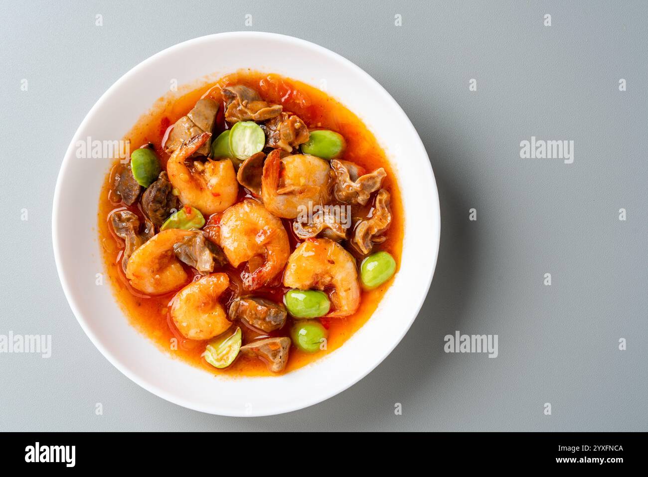 Chili prawns or Sambal Udang with petai or pete served in white plate ...