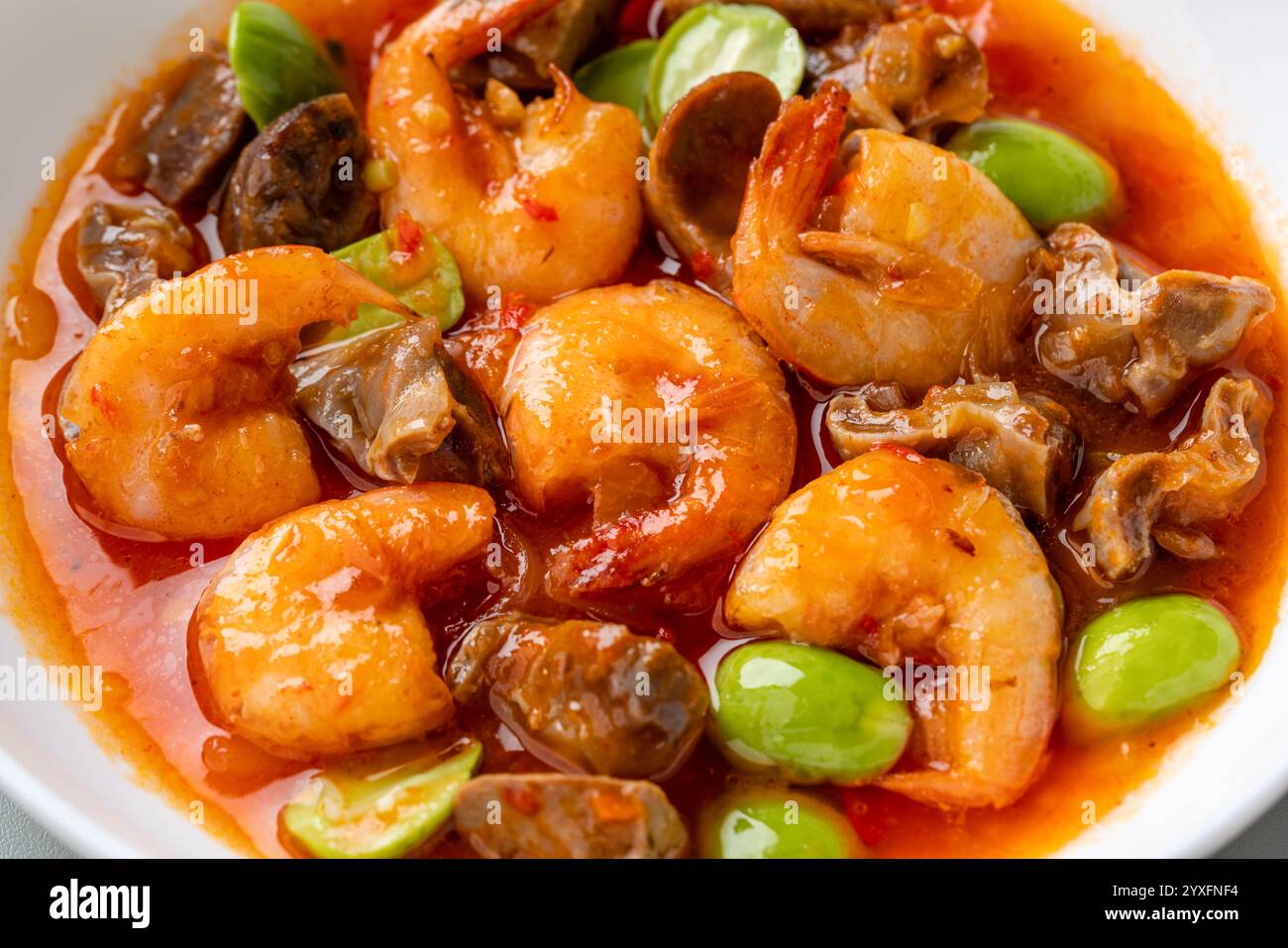 Chili prawns or Sambal Udang with petai or pete served in white plate ...