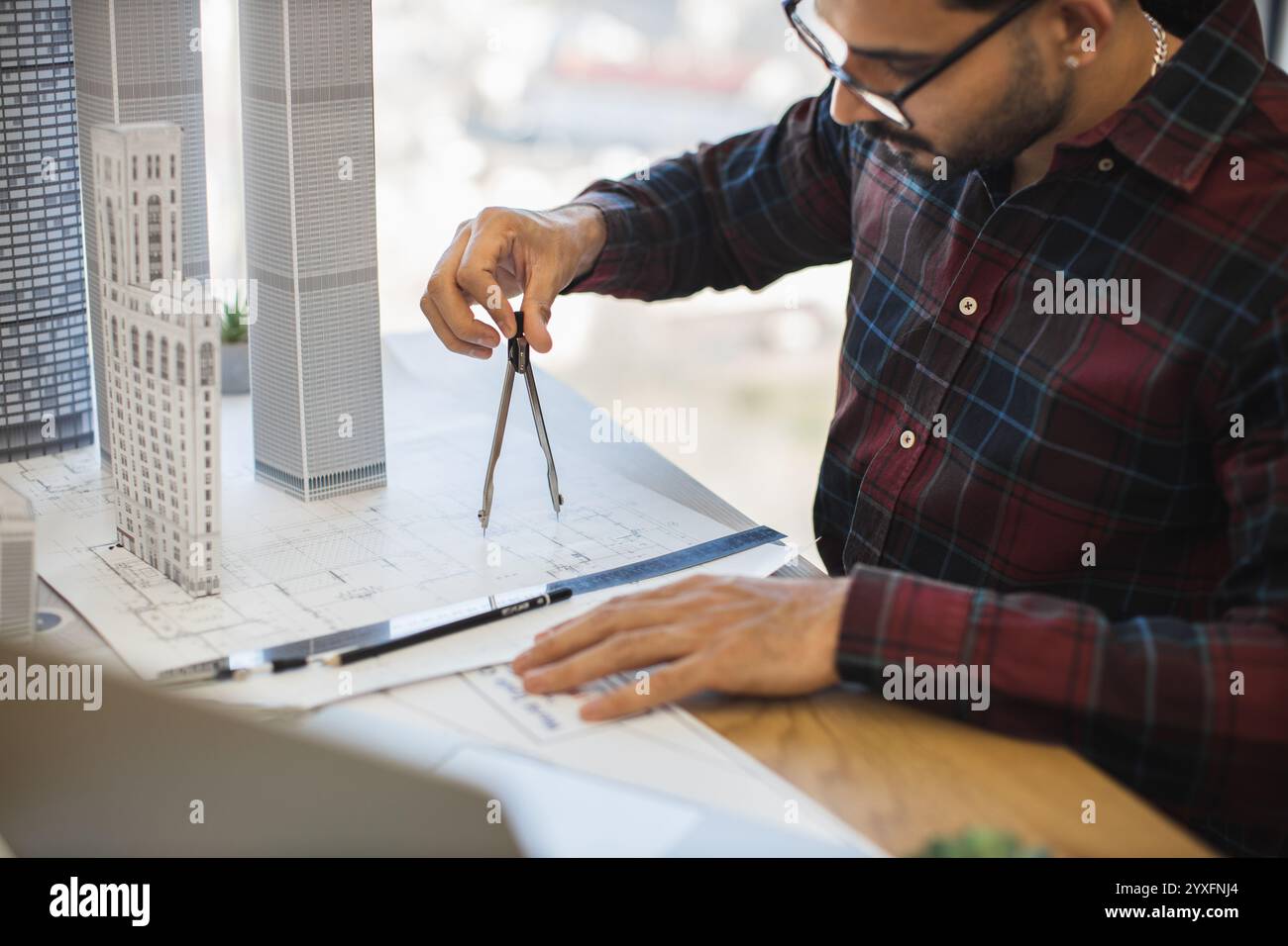 Indian male architect using compass to measure distance on urban city ...