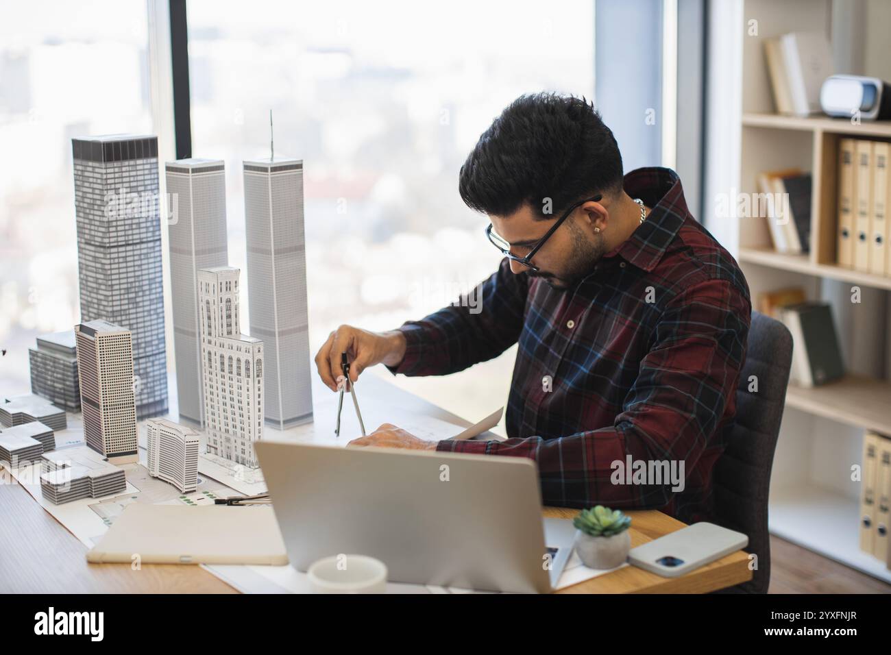 Indian male architect in modern office measures city model showcasing ...