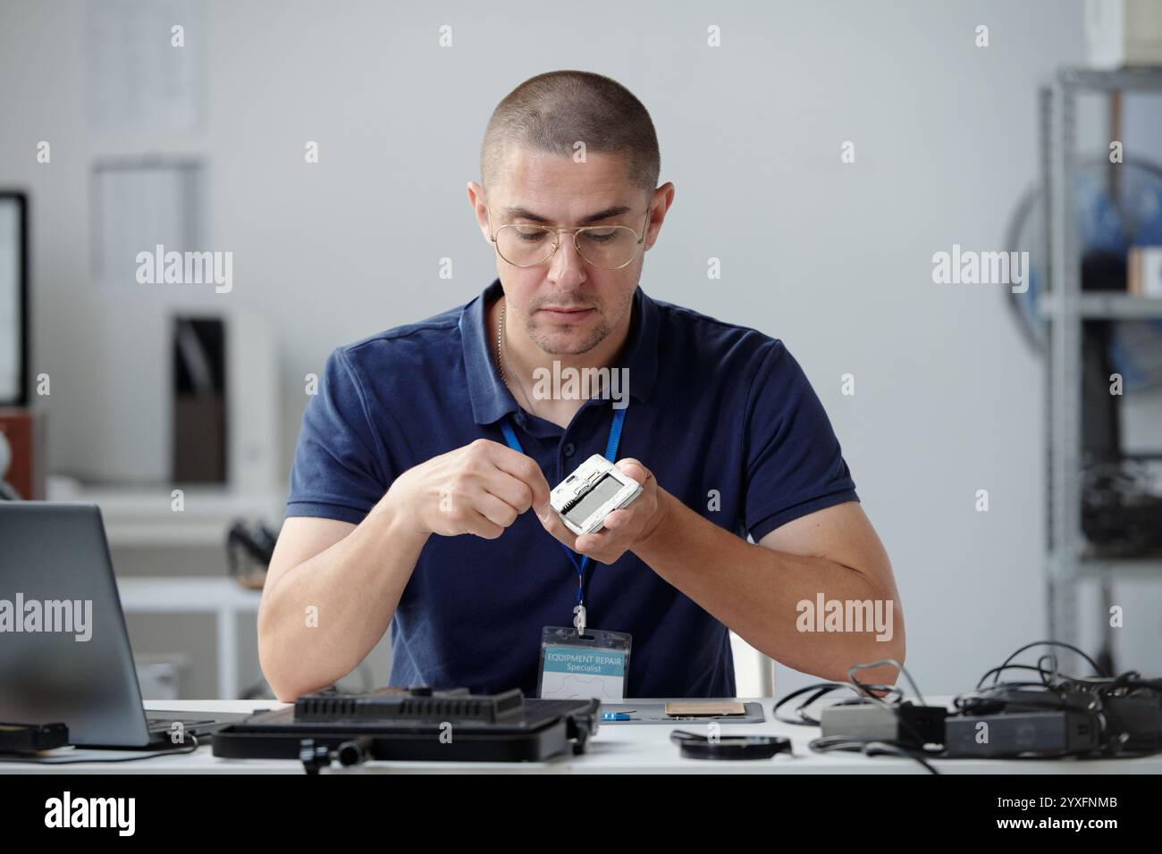 Man Examining Technical Device at His Desk Stock Photo - Alamy