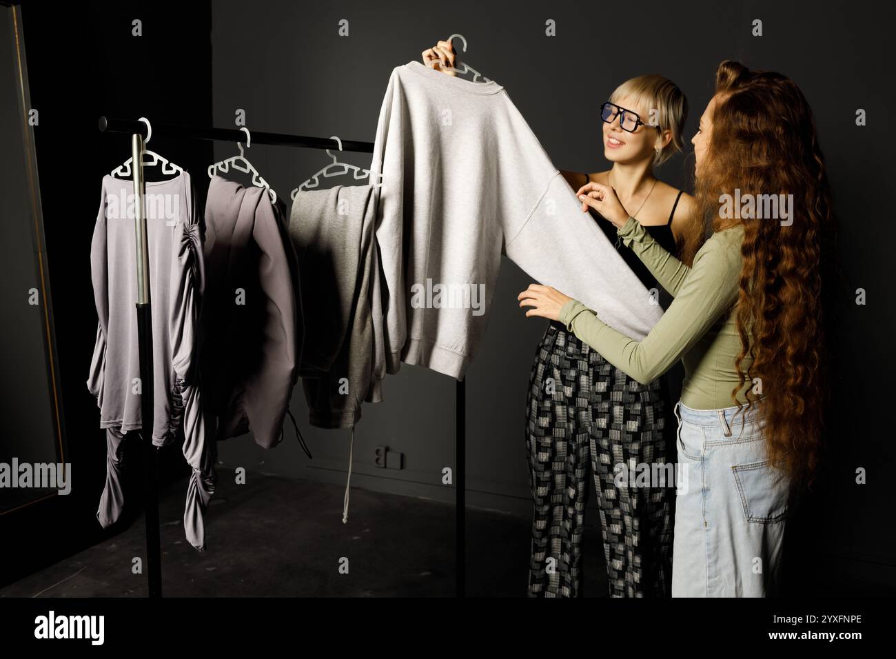 Stylist designer helping choose clothes dress to customer client Stock ...