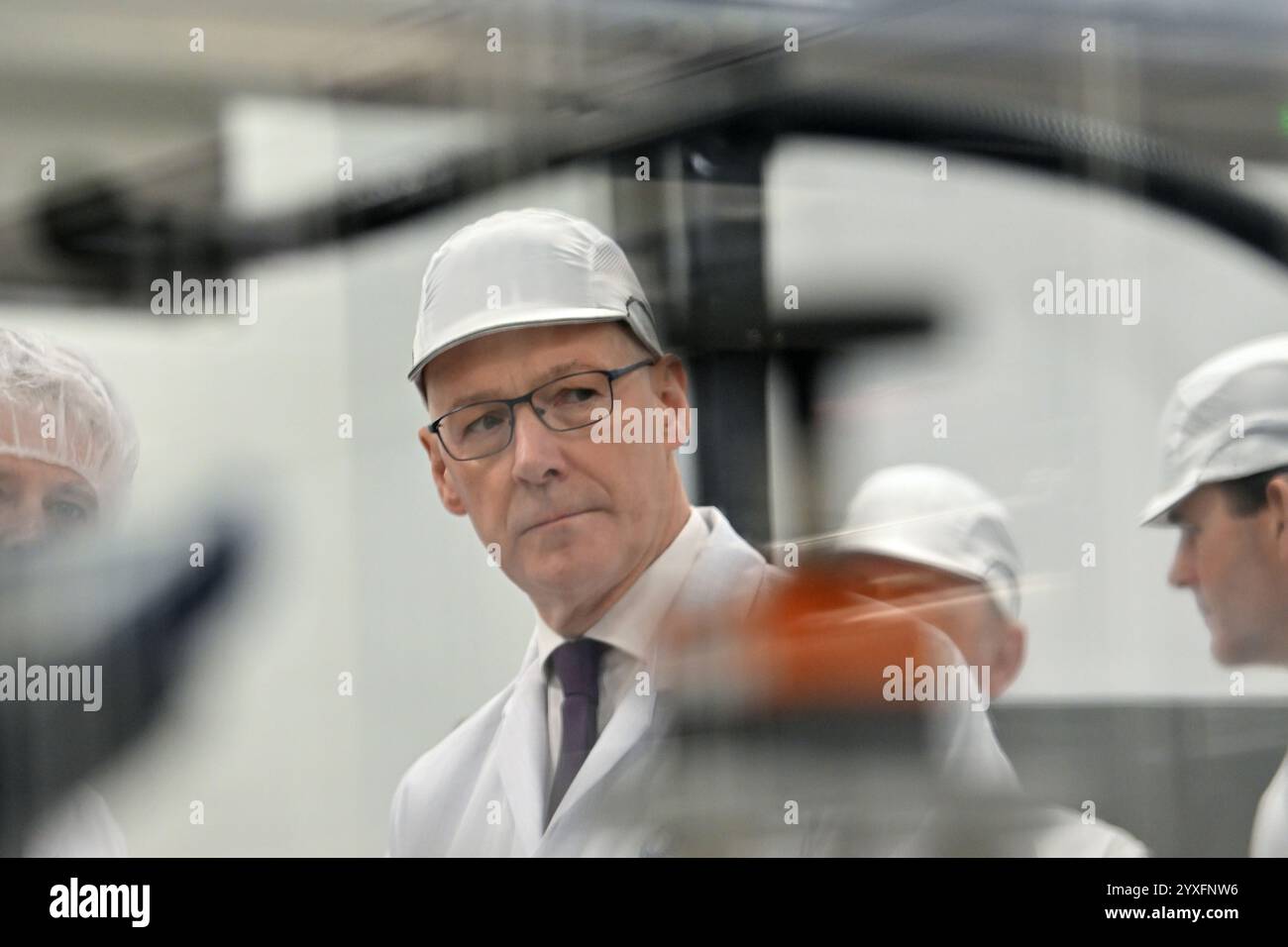 First Minister of Scotland John Swinney looks at machinery while ...