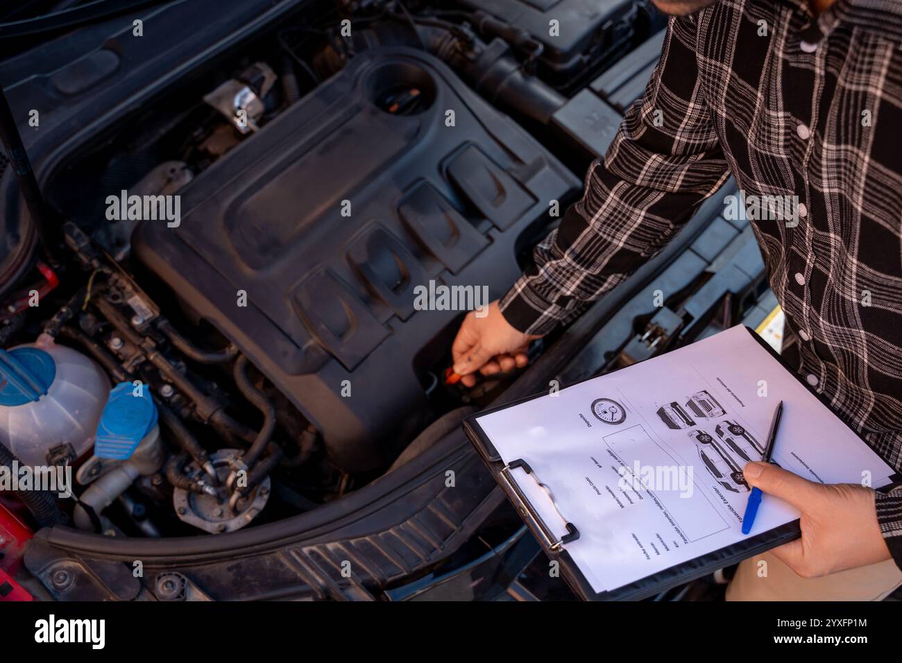 Car mechanic checking the engine oil level and comparing it with the ...
