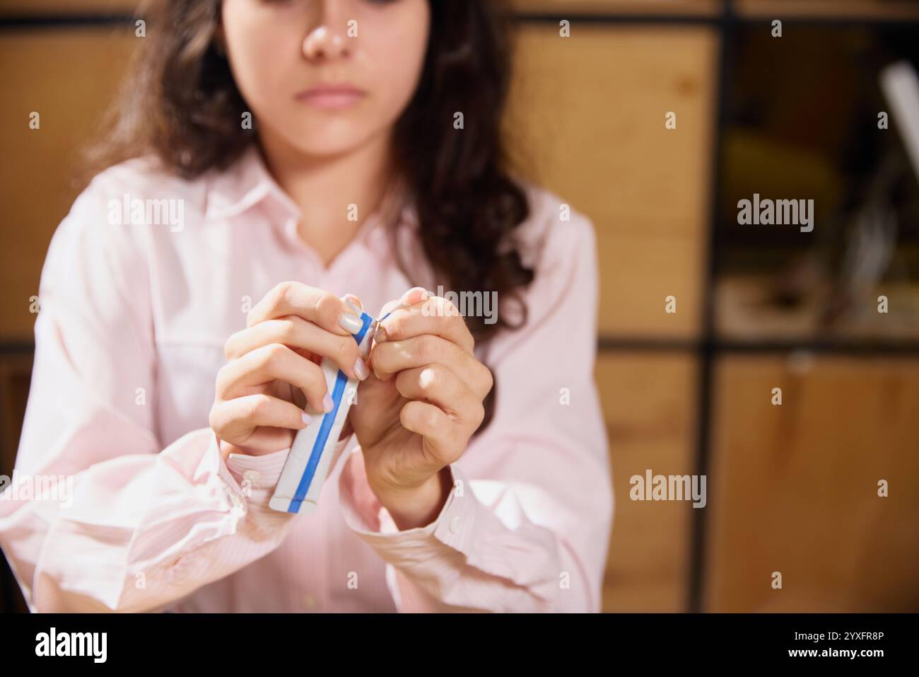 Woman dressed office attire, unpack medical preparation in sachet ...