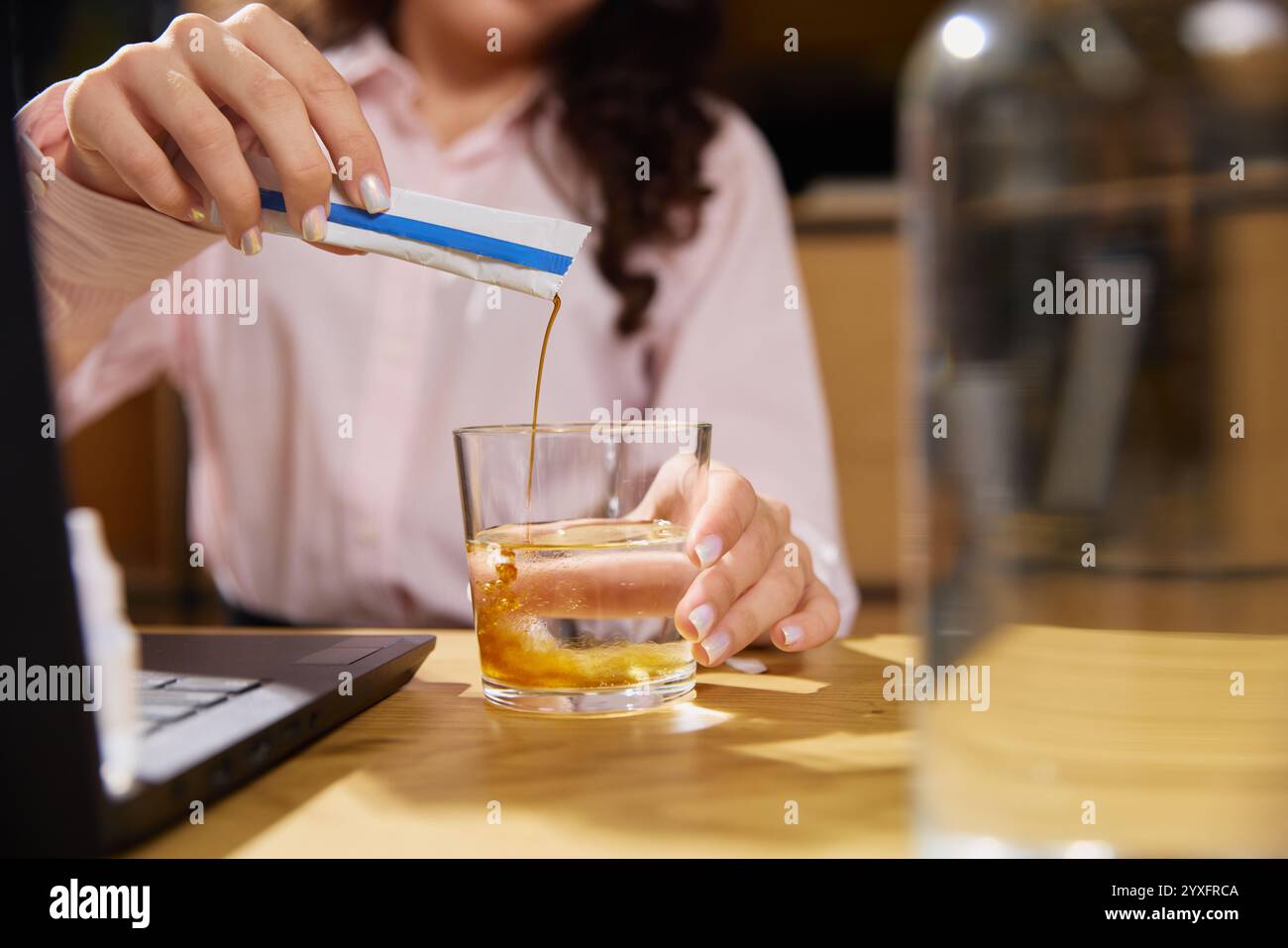 Woman dressed office attire pours liquid, medical preparation from ...