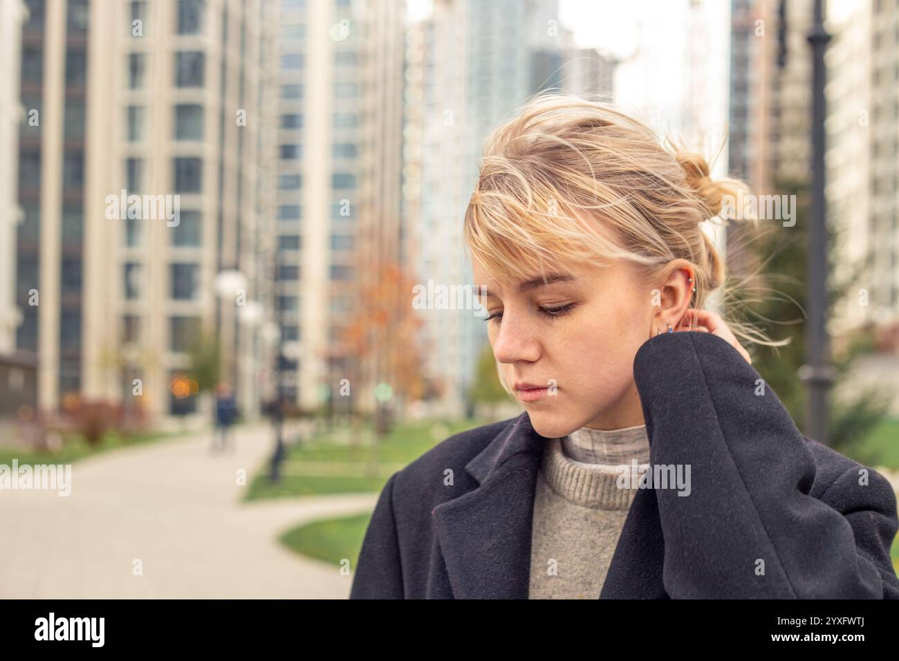 Sad young woman in the city. The woman is cold outside. A walk in the ...