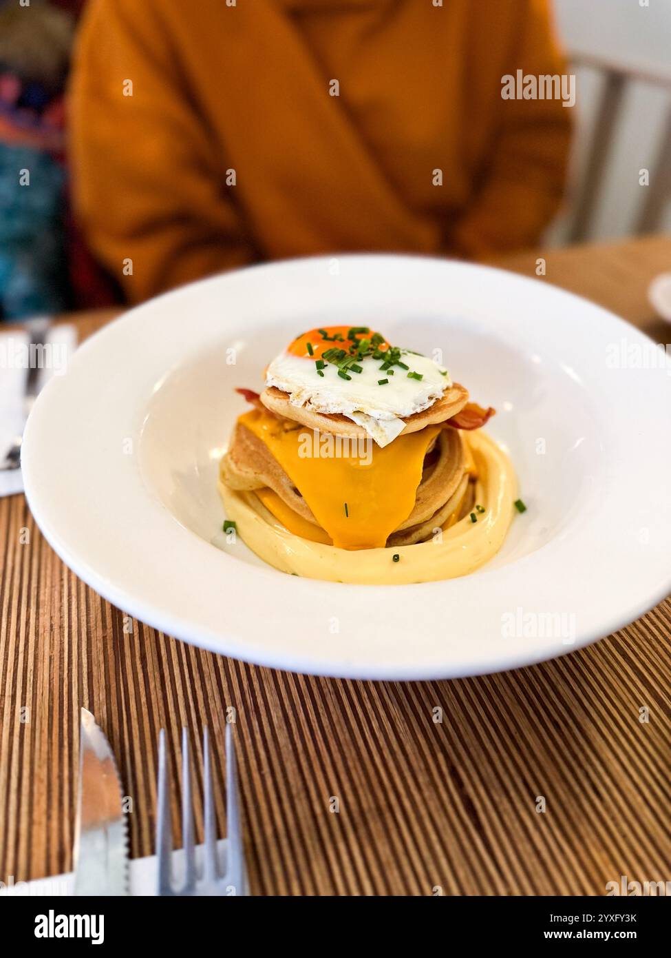 Salty pancake with egg, cheddar cheese sauce and bacon served at ...