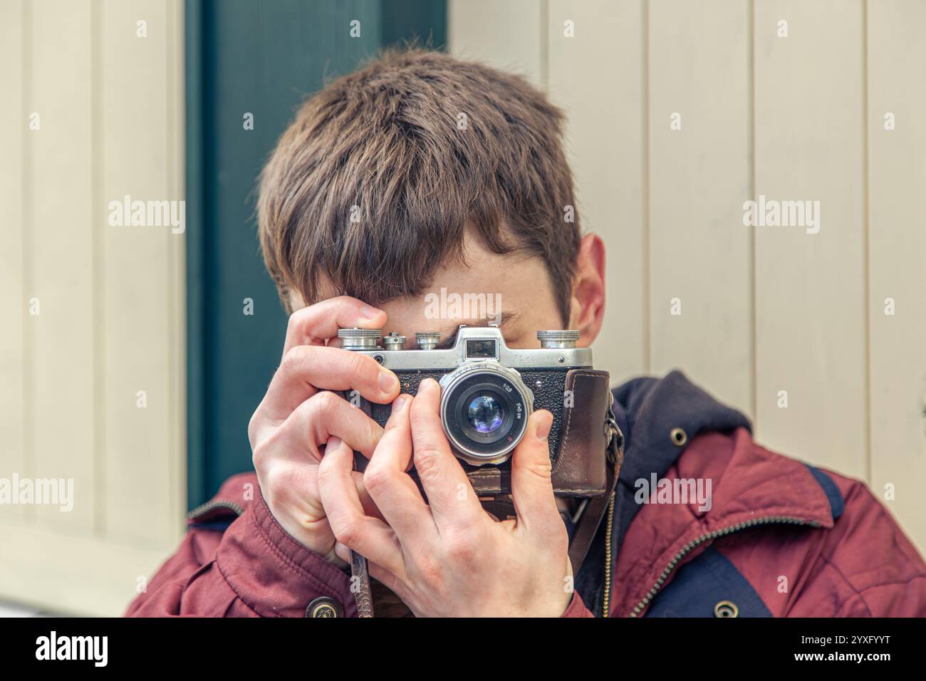 A young man takes pictures on a vintage camera. Film camera photography ...