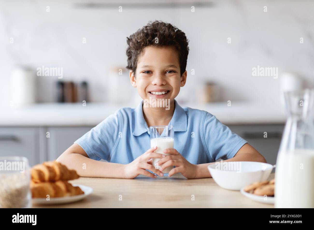 Boy enjoying a joyful moment in the kitchen with snacks and milk Stock ...