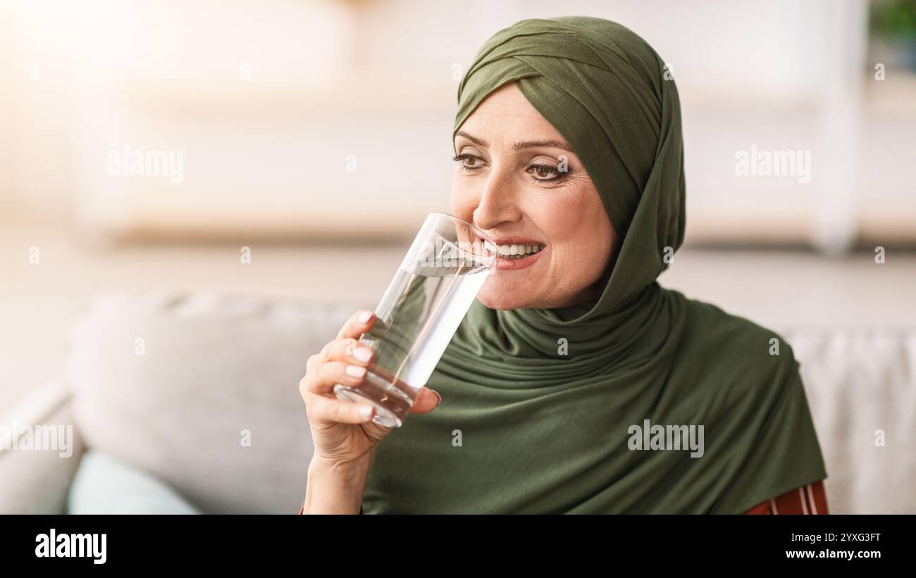 Cheerful Senior Muslim Lady In Hijab Drinking Water At Home Stock Photo ...