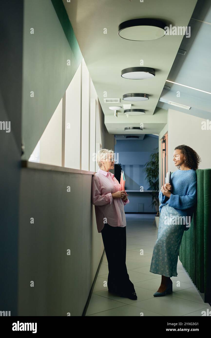 Vertical full length shot of senior and younger female colleagues ...