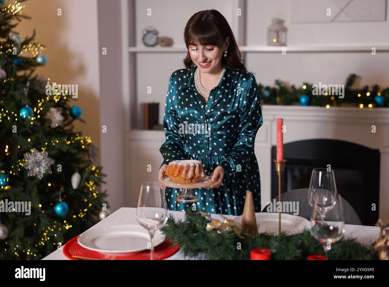 Woman setting table for Christmas dinner at home Stock Photo - Alamy