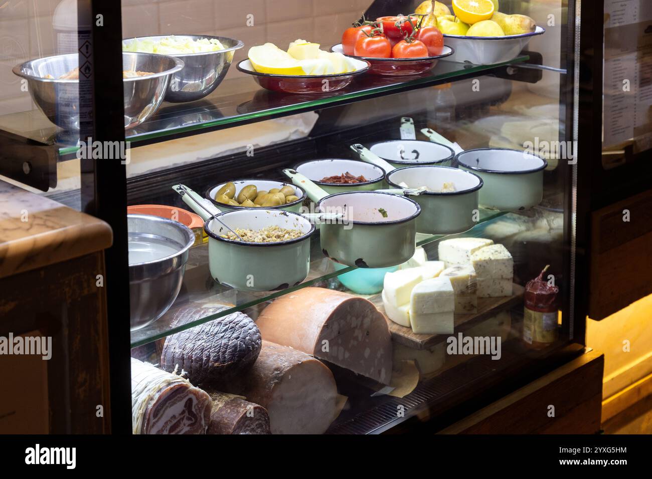 An artisanal delicatessen display in Rome with fresh cheeses, cured ...