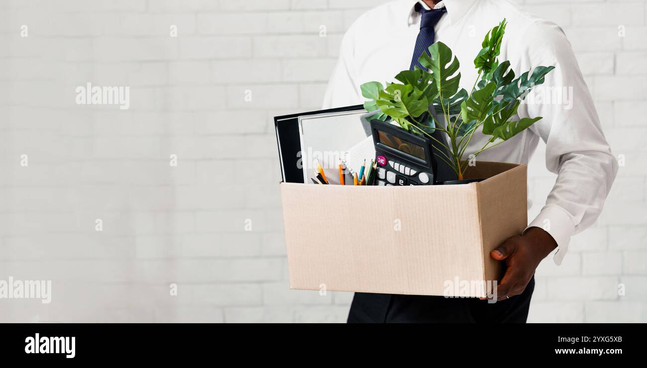Losing job. Closeup view of African American guy with box of his stuff ...