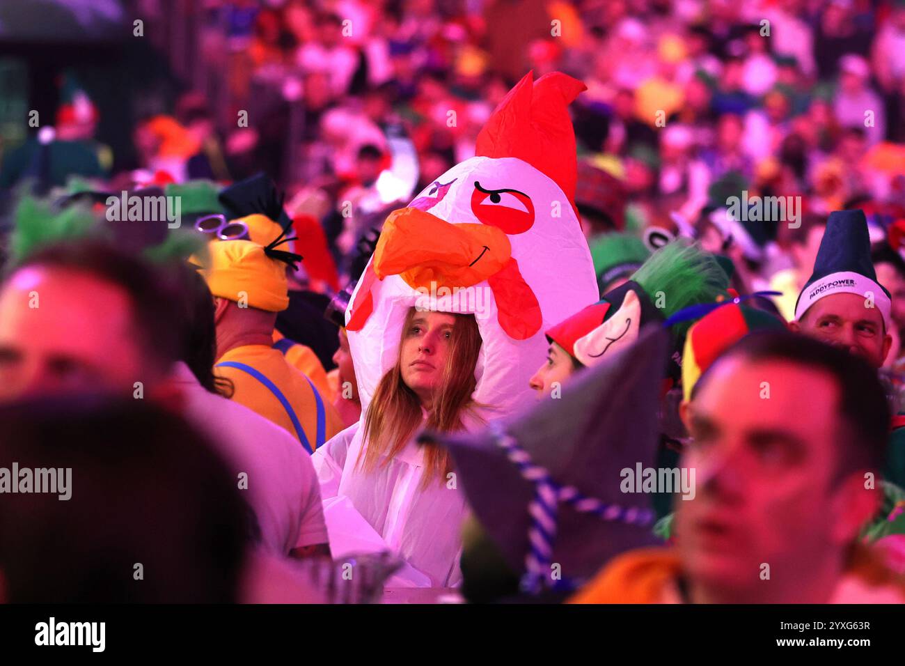 A fan wearing an oversized chicken outfit watches the action during day ...
