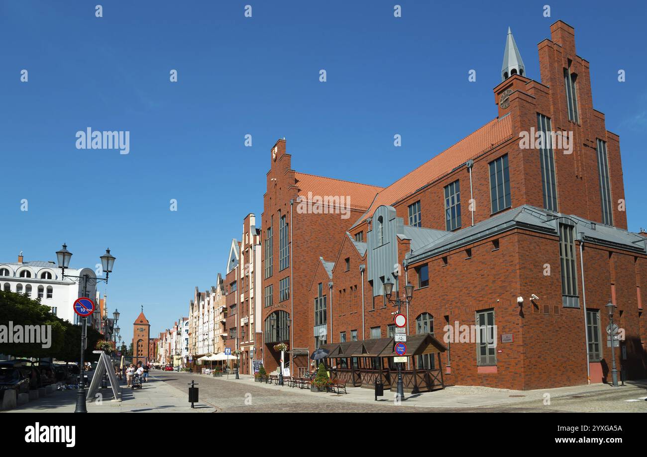 Historic street with brick buildings and towers under a clear blue sky ...