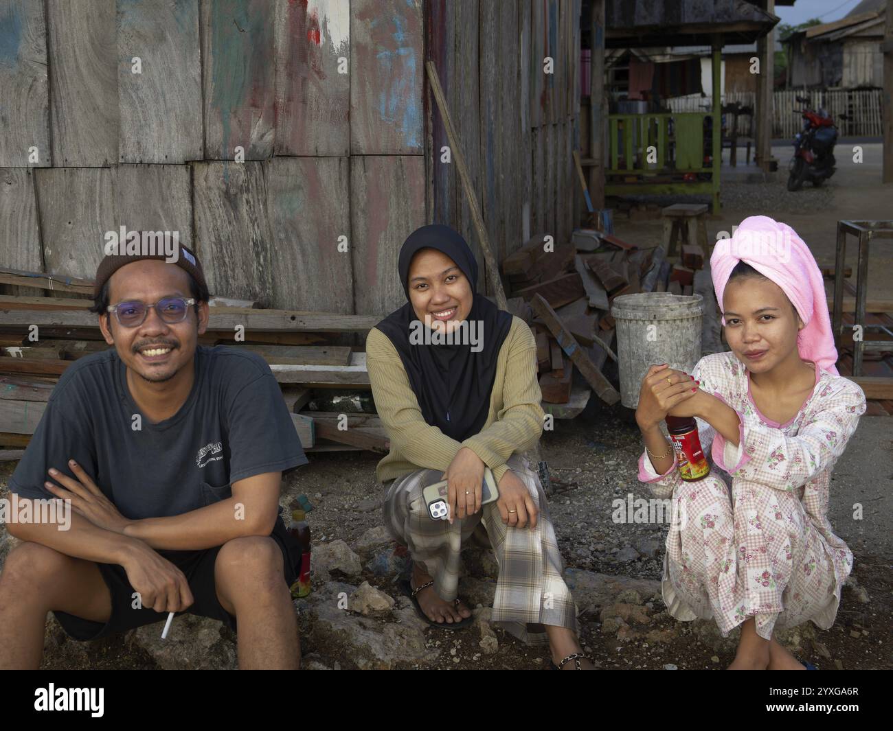 Muslim woman and man in village sitting in front of hut, Tana Beru ...