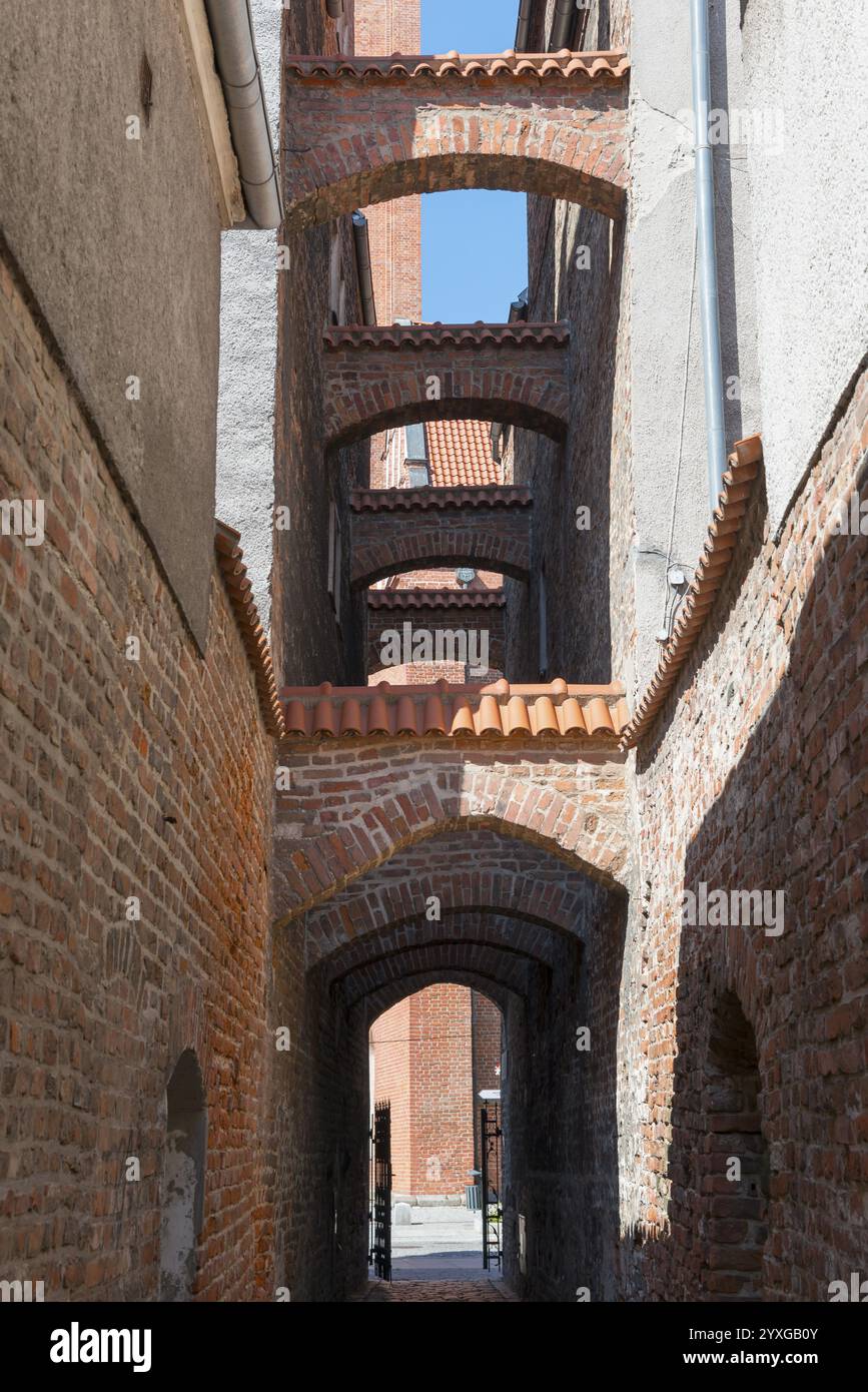 A narrow, arched passageway made of bricks with historical flair, 13th ...