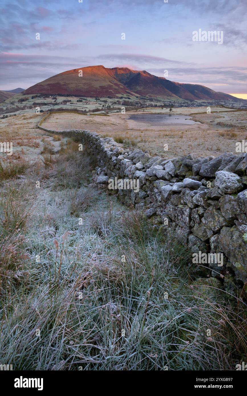Frozen stone wall on a frosty winter morning with view of Blencathra ...