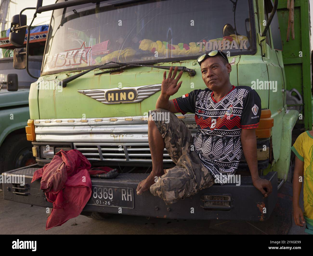 Truck driver sitting on bumper, harbour of Makasar, Sulawesi, Indonesia ...