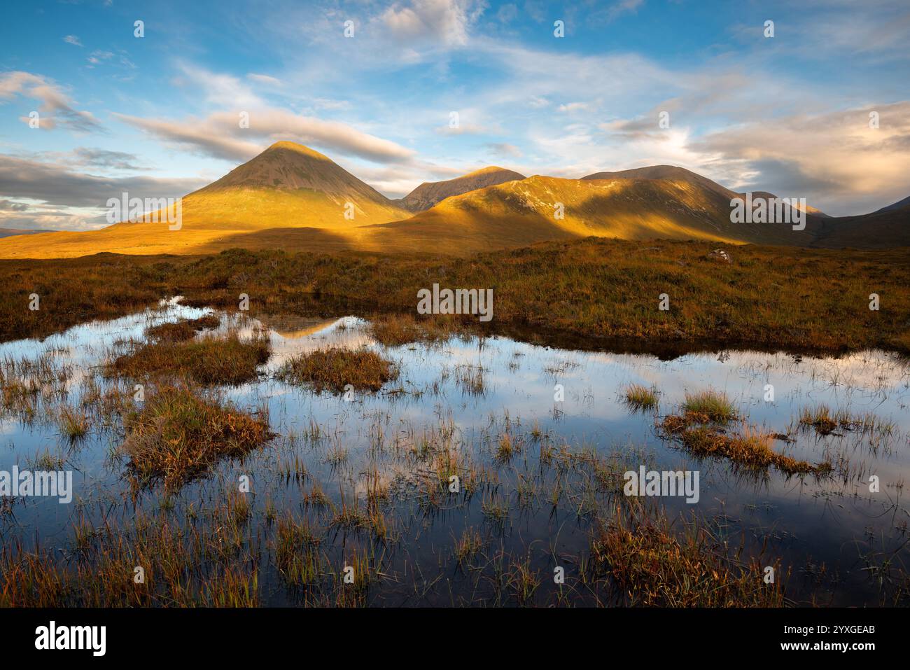 Red Cuillin mountains covered in golden light seen from Sligachan. Isle ...