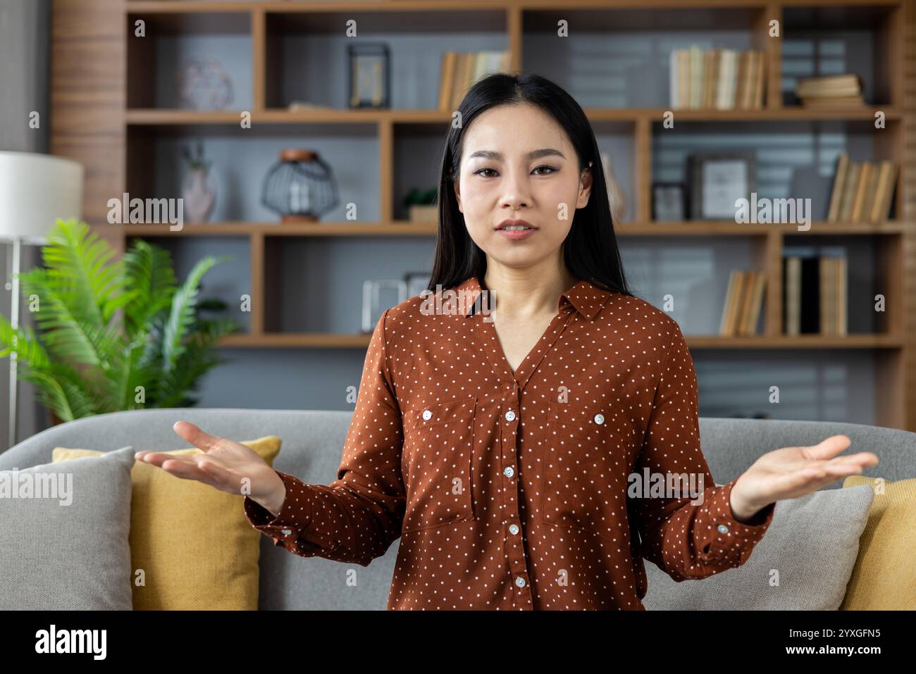 Confident Asian woman gesturing openly, expressing understanding and ...