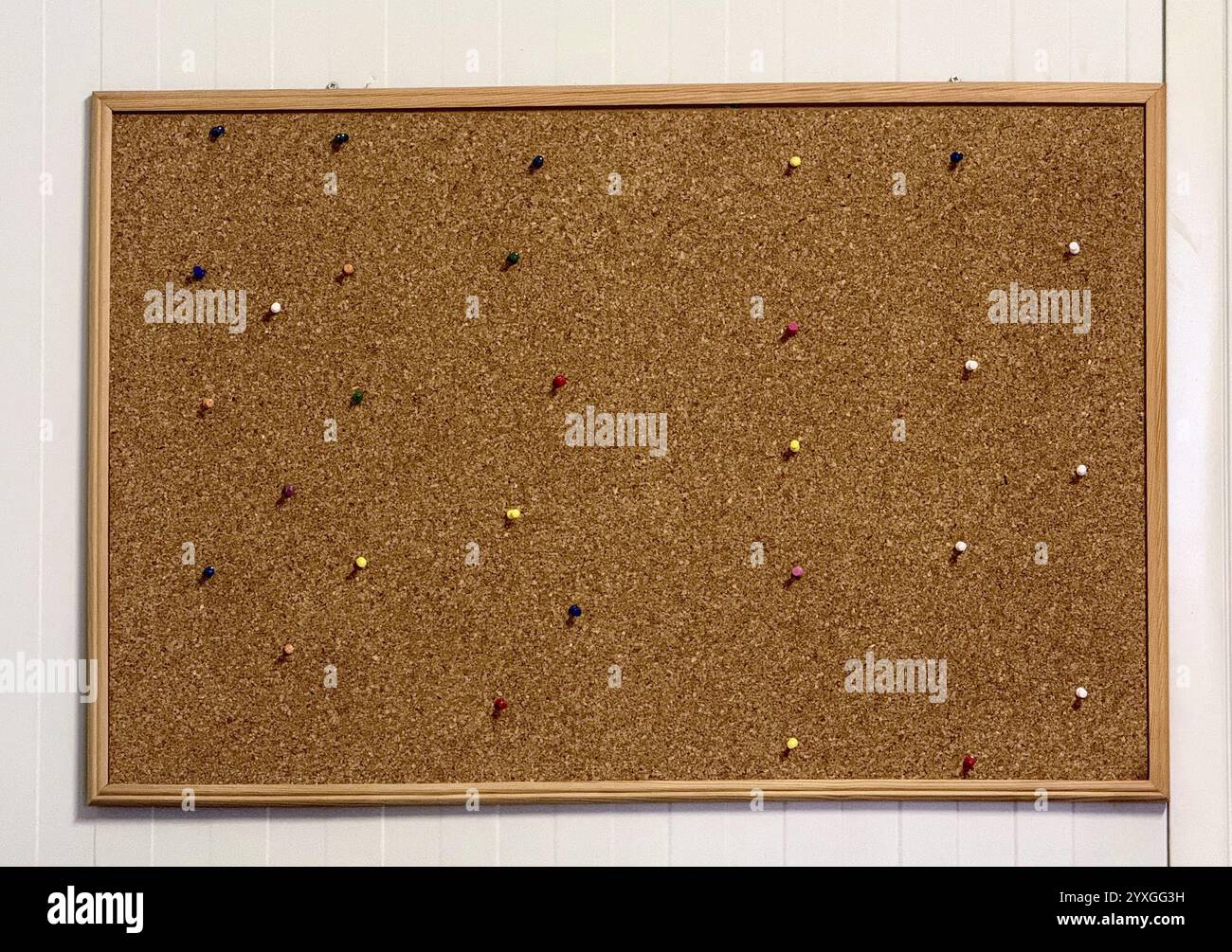 Cork bulletin board with various colored push pins on a wall Stock ...