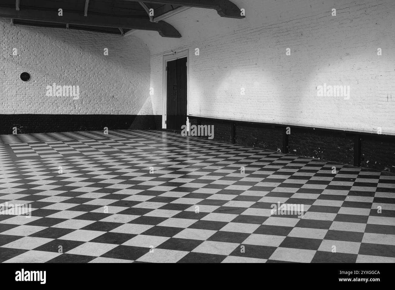 Chequered floor covering in front of a white house wall, black and ...