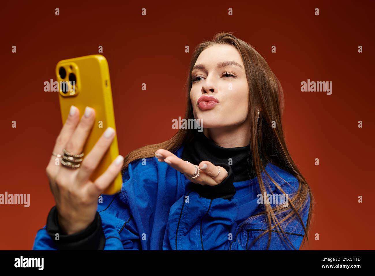 Vibrant woman captures a selfie while blowing a kiss in front of a ...