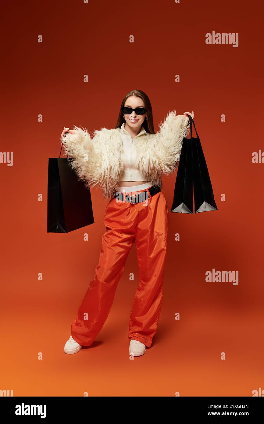 A stylish woman with a vibrant outfit holds shopping bags in a fashion ...