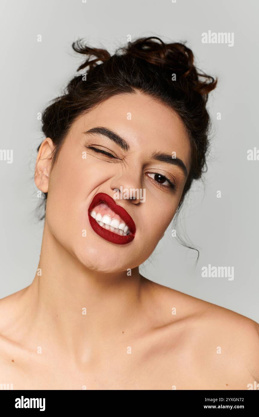 Beautiful woman with striking red lips making a playful face in a ...
