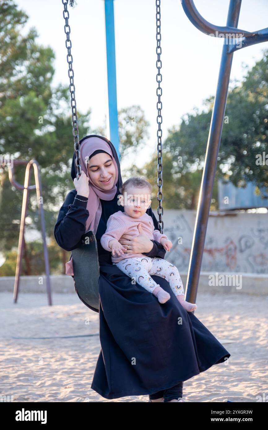 A heartwarming moment capturing a Muslim mother in traditional abaya ...